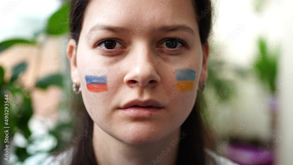 Young Russian-Ukrainian girl with the flag of Ukraine and Russia on her ...