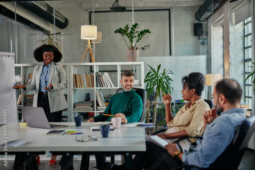 African businesswoman giving presentation in front of her colleagues in ...
