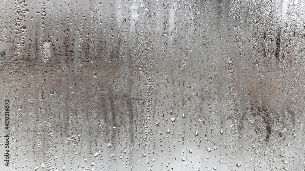Close up for misted glass with droplets of water draining down ...
