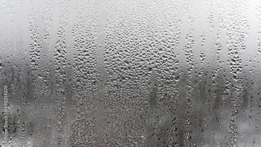 Close up for misted glass with droplets of water draining down ...