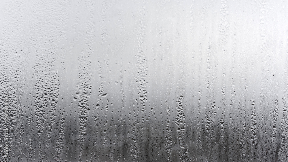 Close up for misted glass with droplets of water draining down ...