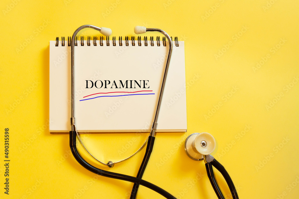 Dopamine - medical name on a yellow background next to a stethoscope ...