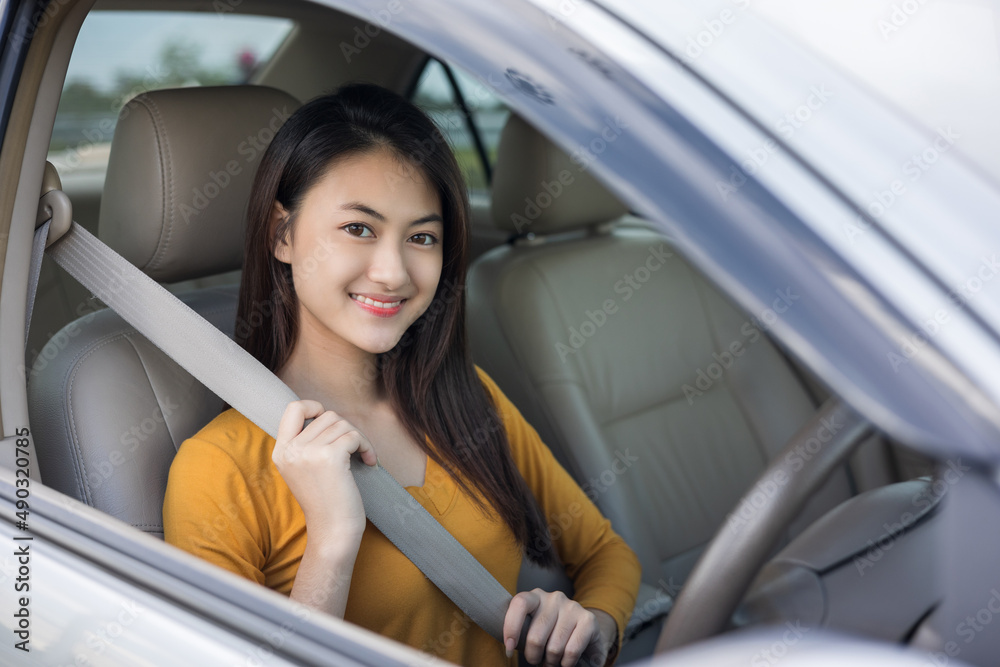 Young beautiful asian women getting new car with safety belt. she very ...