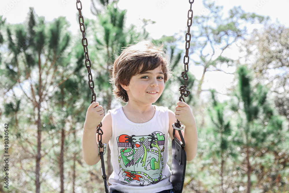Little boy playing on a swing in moss park on Lake Nona Florida in ...