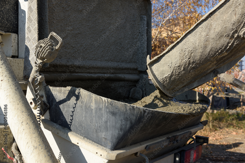 Pouring concrete at a construction site. The concrete is poured into ...