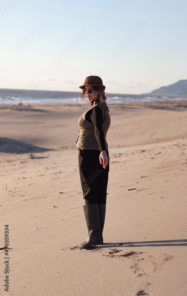Back view of young woman with black boots and bron hats. She is looking ...