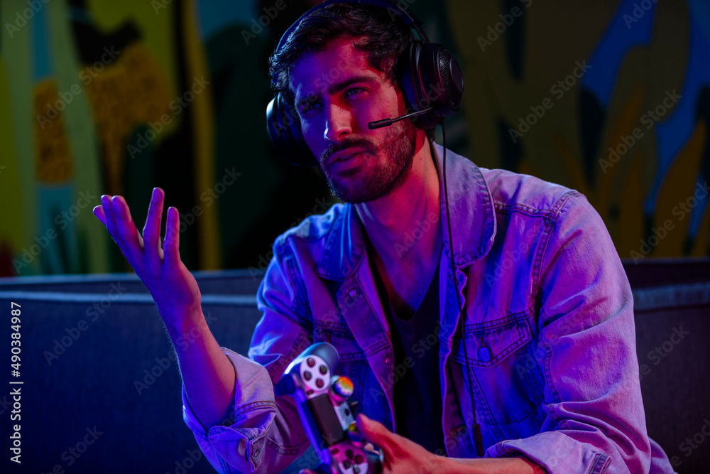 Gamer making a frustrated expression at TV while playing at home in ...