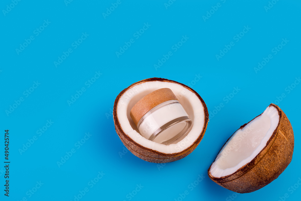 Coconut cream in glass jar with fresh coconut split in half on isolated ...