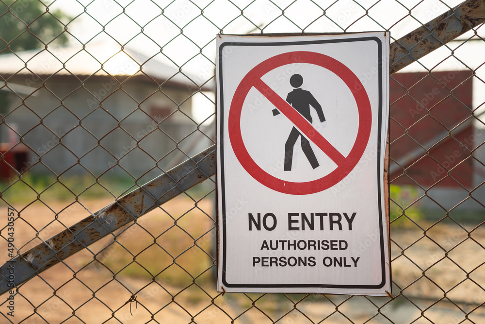 "No Entry" information metal sign plate on the wire fence which is ...