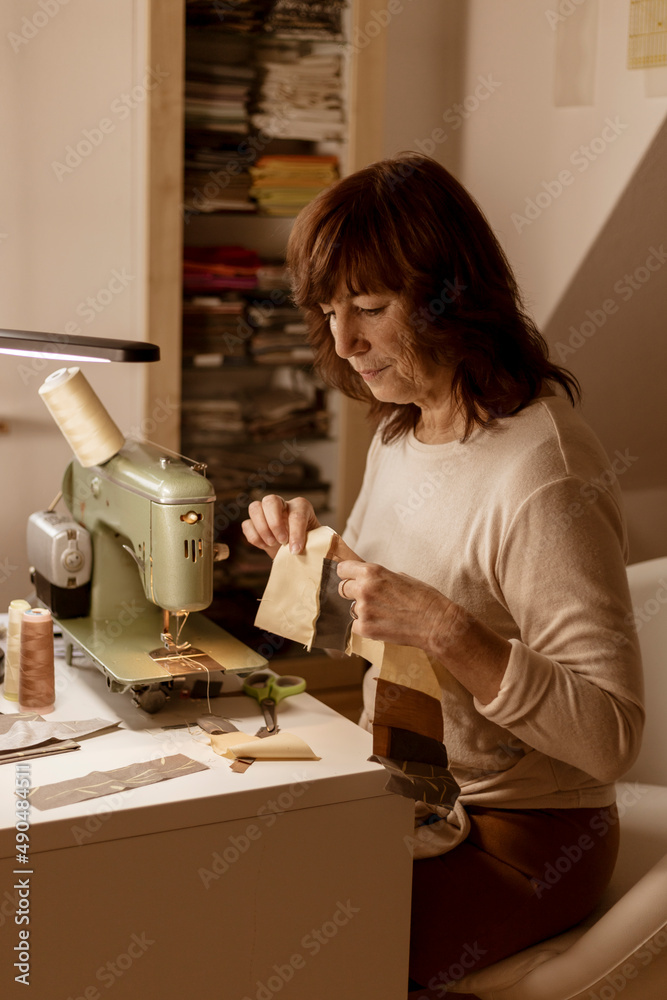 Caucasian brunette woman sewing fabric with a vintage, retro sewing ...