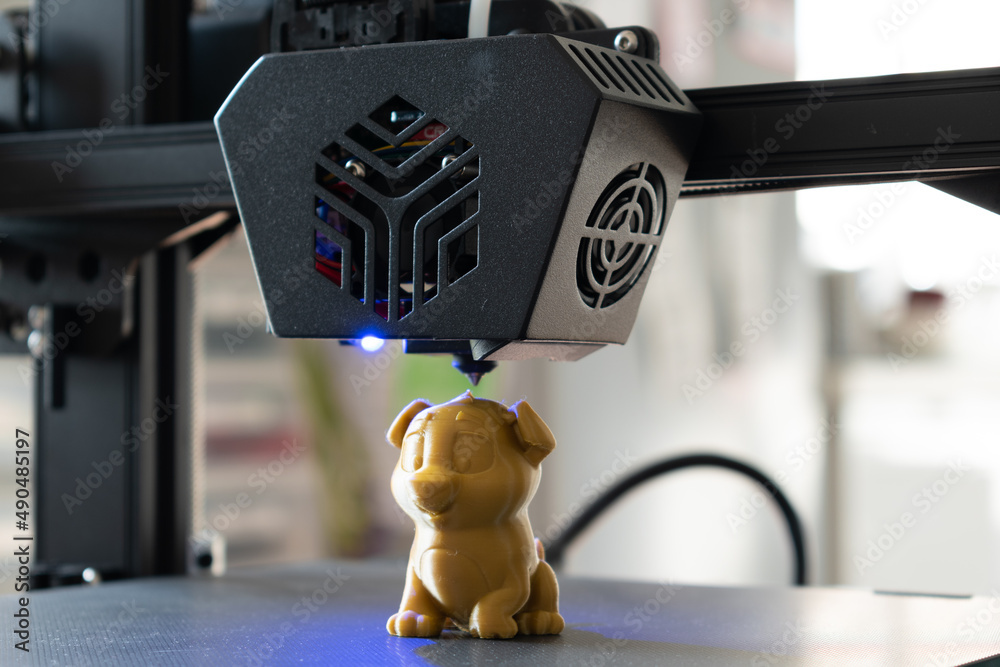 Detail of a 3D printer printing a model with a gold biodegradable PLA ...