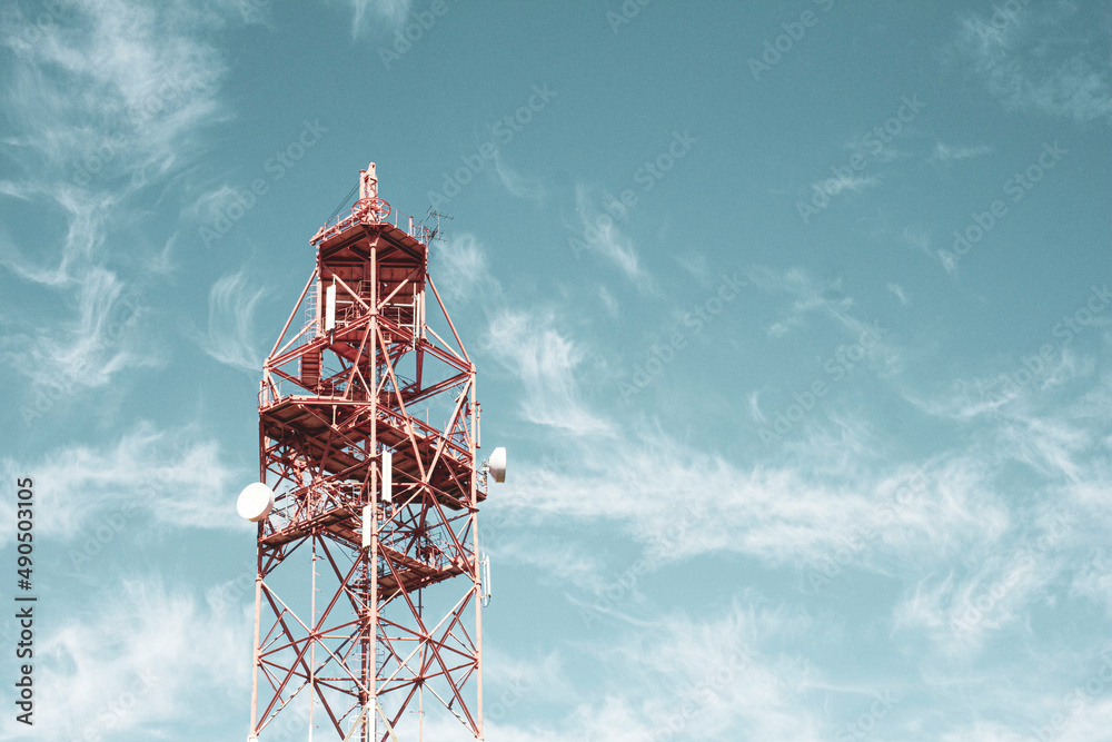 a television cell tower on the border of two states against a blue sky ...