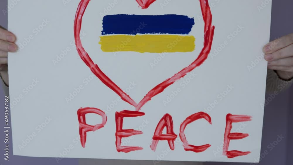painting yellow blue Ukraine flag with drawing red heart around symbol ...