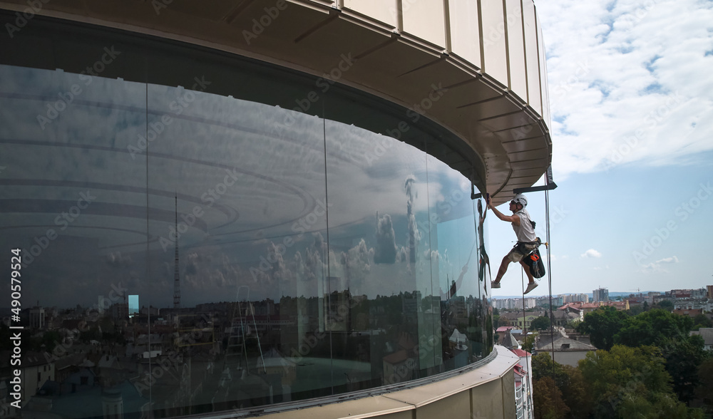 Industrial mountaineering worker professional window washer hanging on ...