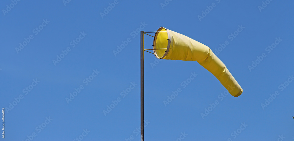 Yellow windsock on a pole with a blue sky background. Stock Photo ...