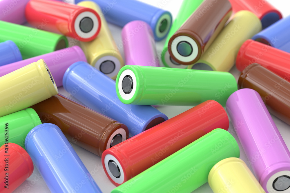 Lots of cylindrical batteries of different colors scattered on a white ...