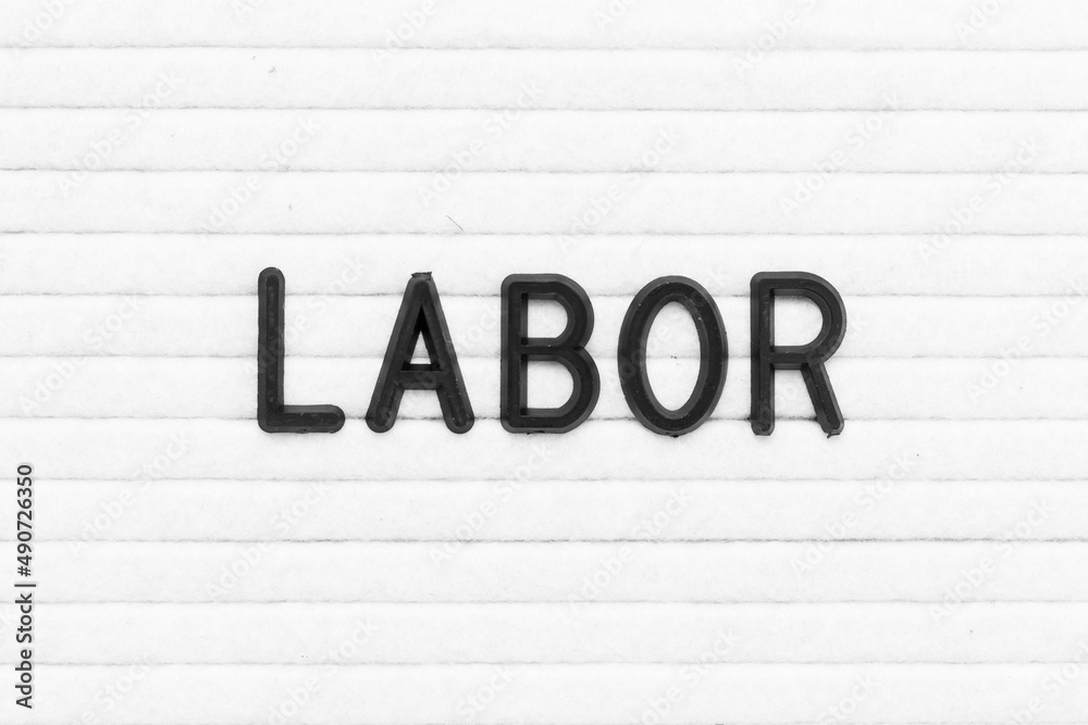 Black color letter in word labor on white felt board background Stock ...