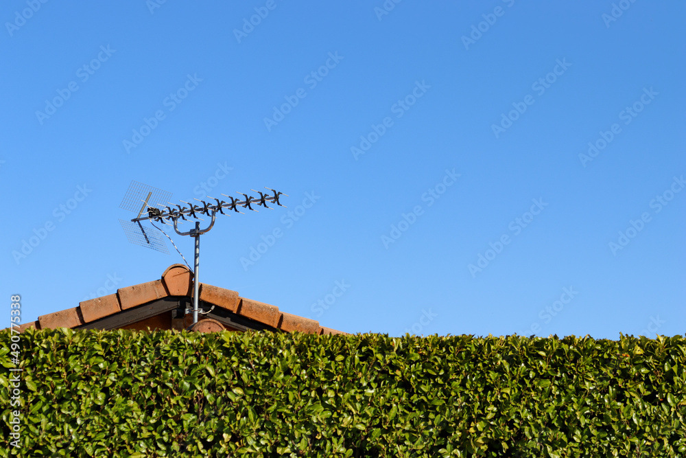 Antenne râteau TV sur le toit d'une maison résidentielle, derrière une ...