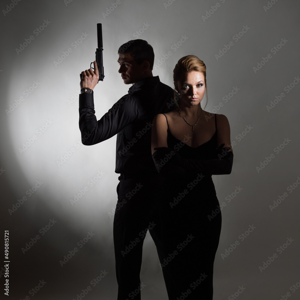 Gorgeous young blonde in a black dress and her bodyguard. A cool couple ...