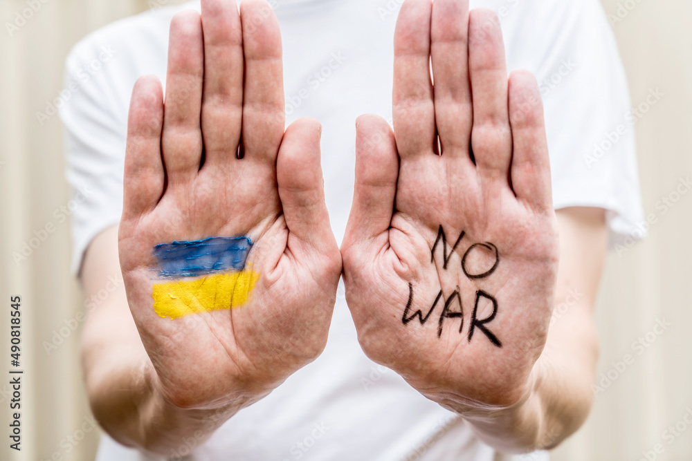 Ukranian flag and no war message painted on hands. Russian Ukraine war ...