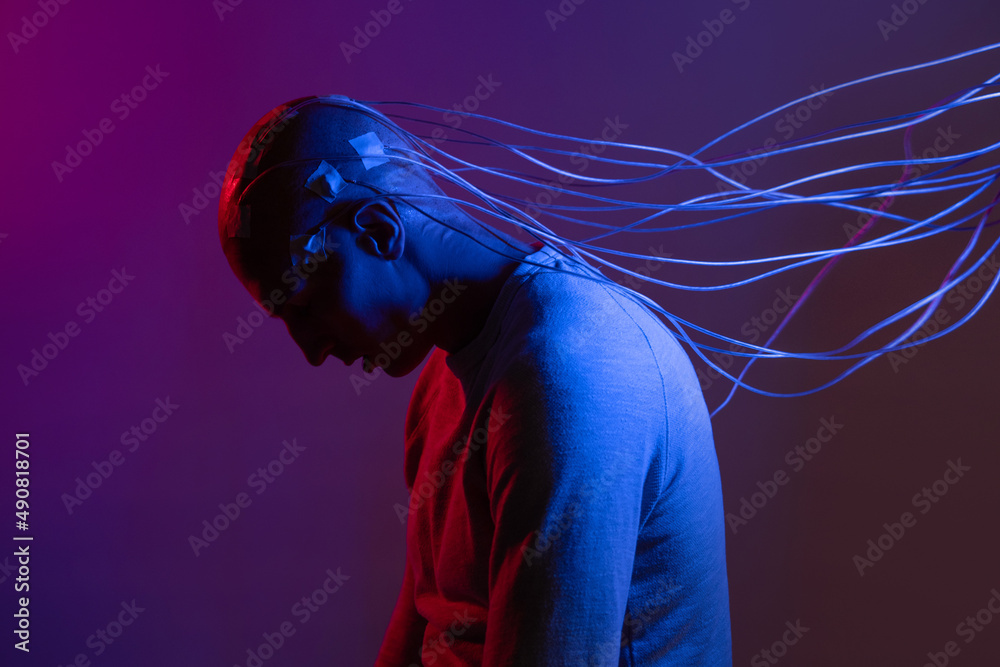 A young man with his head entangled with wires, a portrait in profile ...