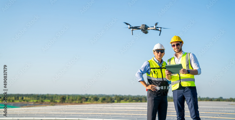 Professional engineer using drone and digital tablet maintaining solar ...