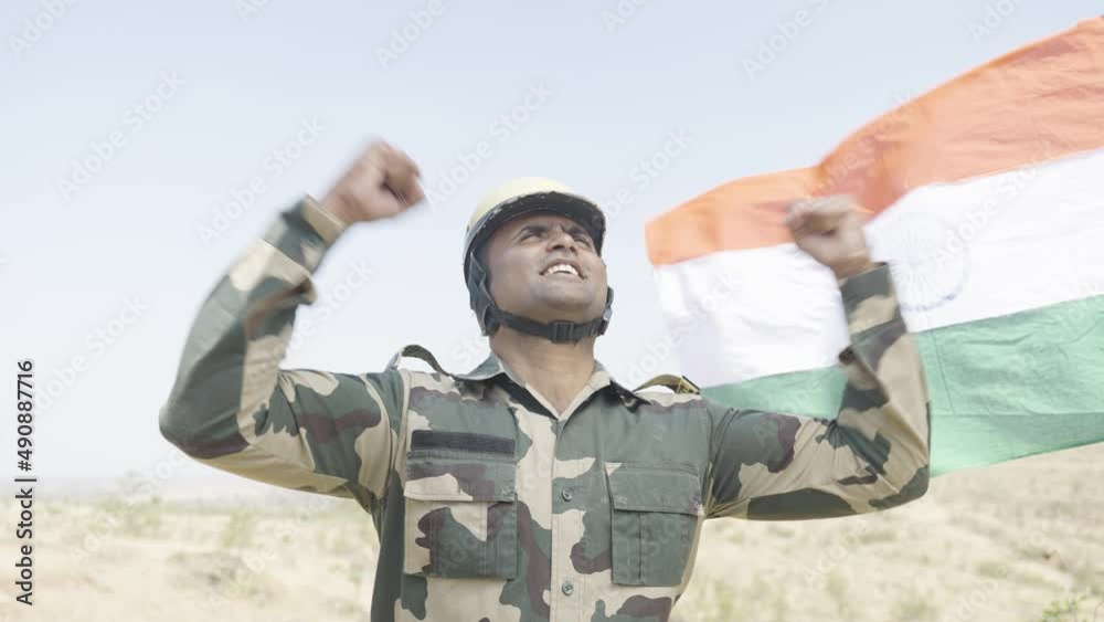 excited army service man shouting by looking above in front of waving ...