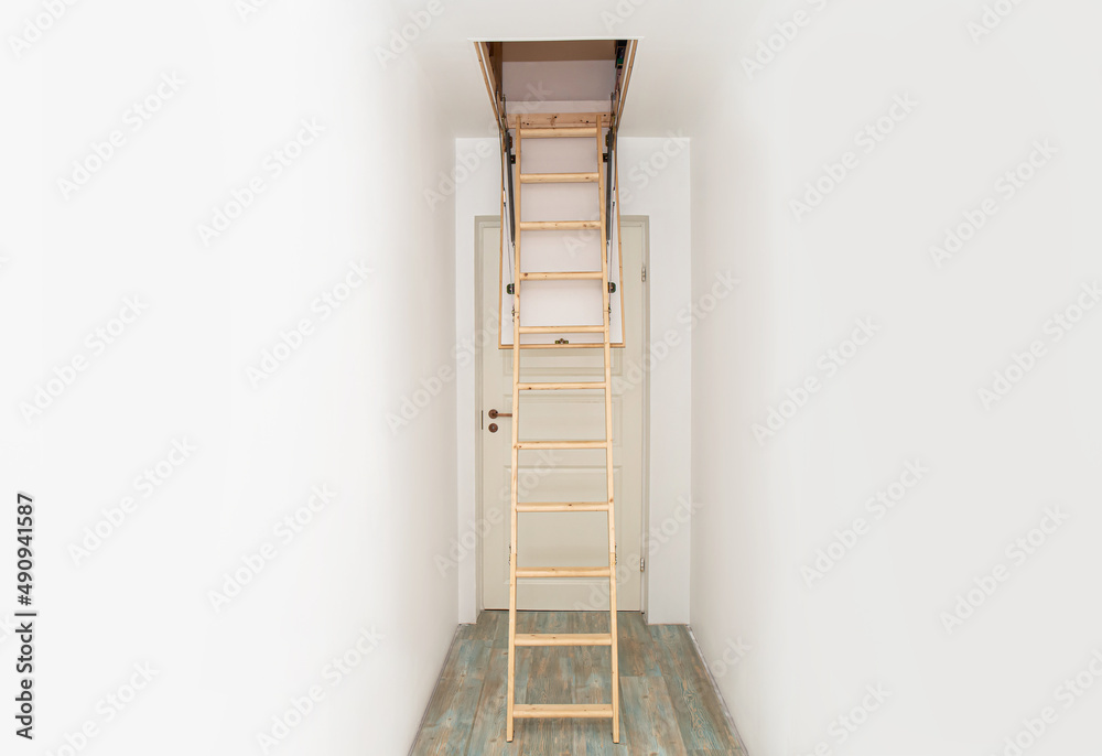 Wooden foldable pull up attic stairs ladder at empty white home ...