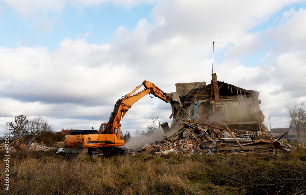 Excavator during demolition the house in the rural. Renovation old home ...