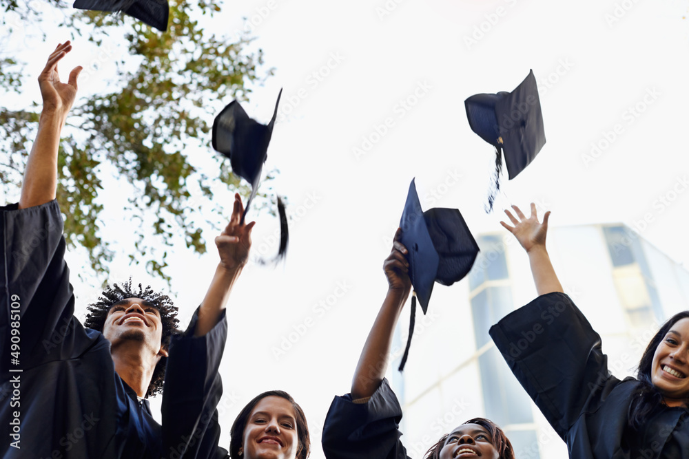 We did it. A group of smiling college graduates celebrating their ...