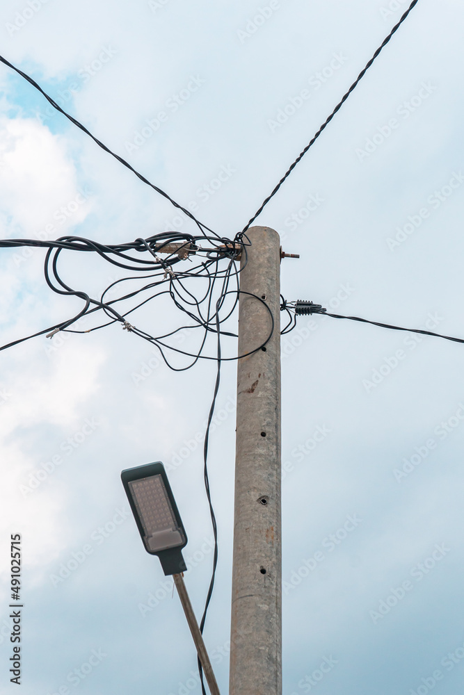 Street electric pole with many electrical wires and fiber optic cables ...