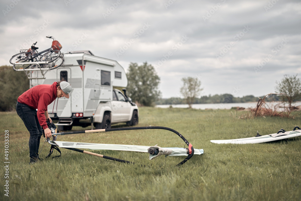 Windsurfer and camper packing and unpacking from a car in nature. Stock ...