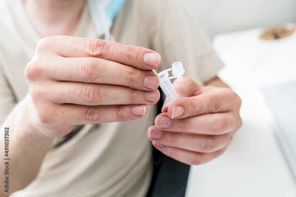 Hands holding Covid-19 rapid antigen test kit tube and cotton swab ...