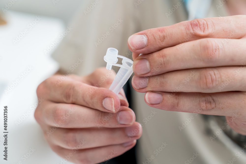 Hands holding Covid-19 rapid antigen test kit tube and cotton swab ...