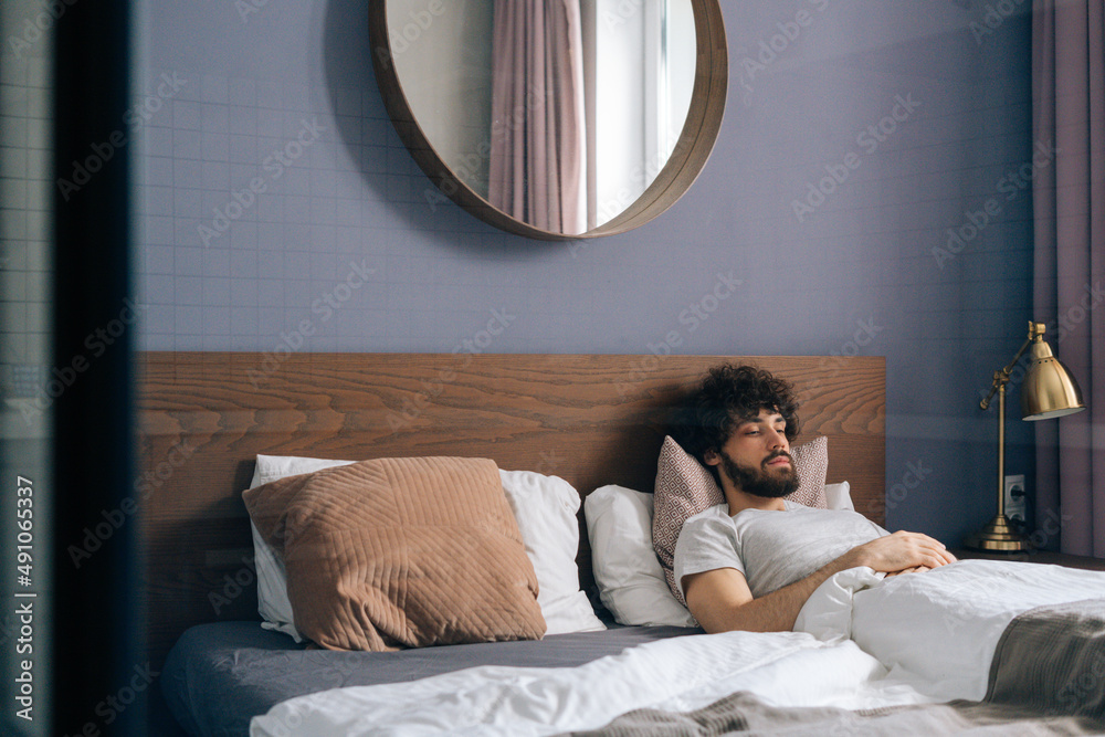 Remote view of tired handsome bearded young man sleeping peacefully ...