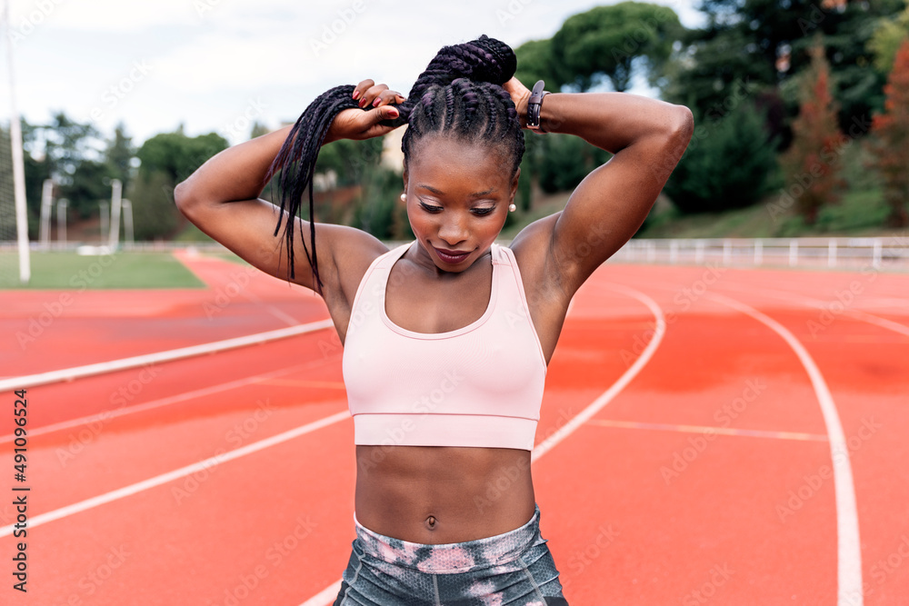 Athlete sprinter touching braided hair Stock Photo | Adobe Stock