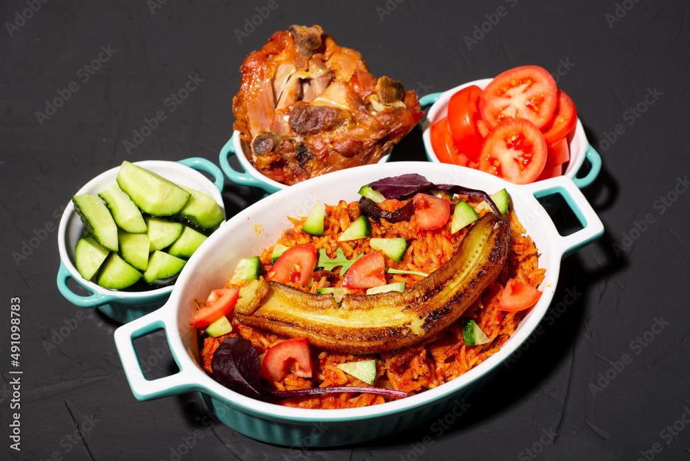 Jollof rice with fried banana, baked chicken. Rice with tomatoes ...