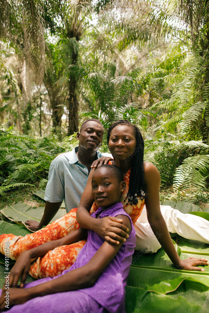 Portrait of a black african family of nature farmers relaxing amongst ...