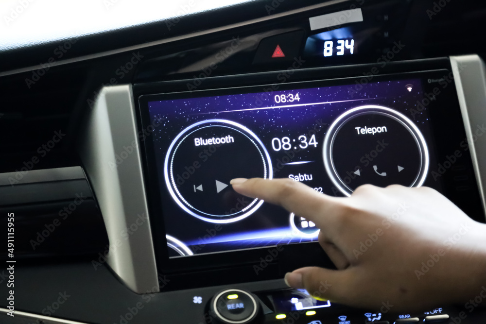 hand pressing the play button on the touch screen advanced car audio ...