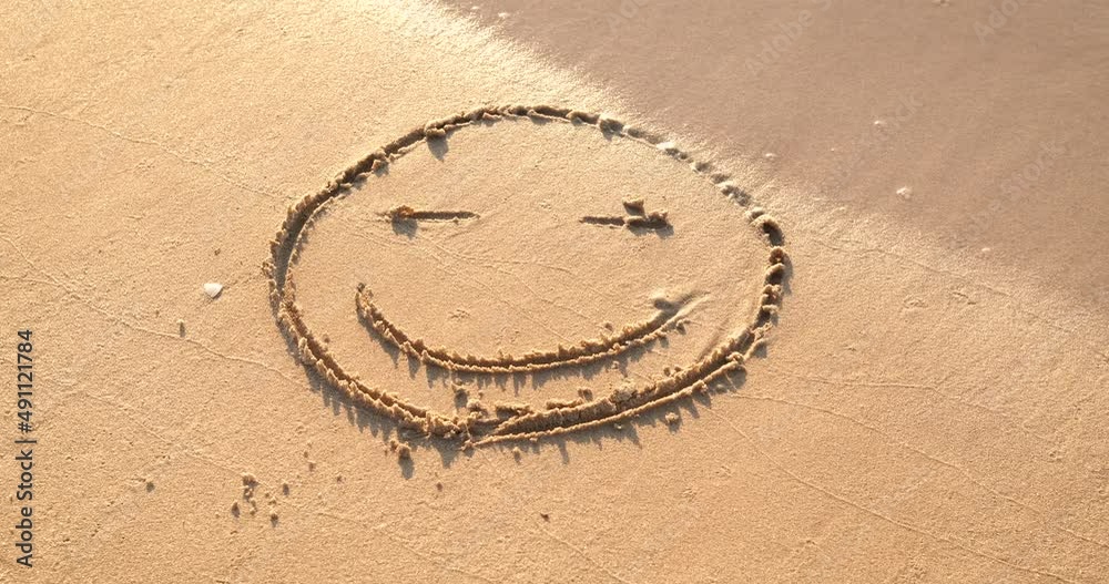 Drawn smile on the sand. The black sea waves wash the drawn smiling ...