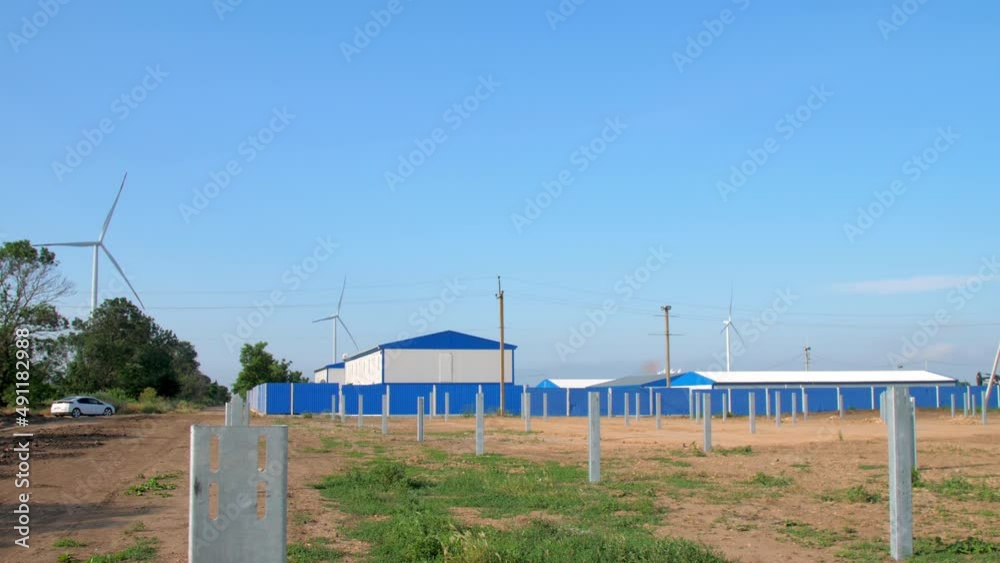 Wind turbines and vertical bars for sun panels installation at electric ...