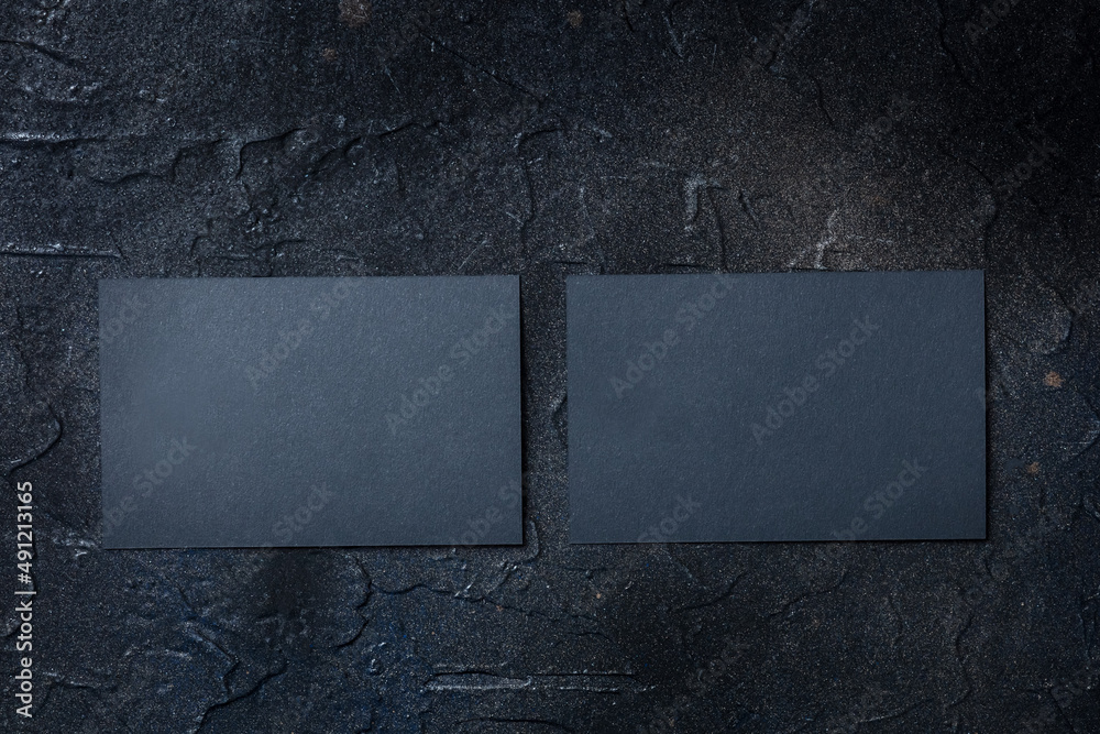 Two black business cards mockup, front and back, on a dark background ...