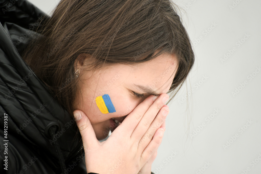 Portrait of Ukrainian girl with national flag on cheek crying, patriot ...