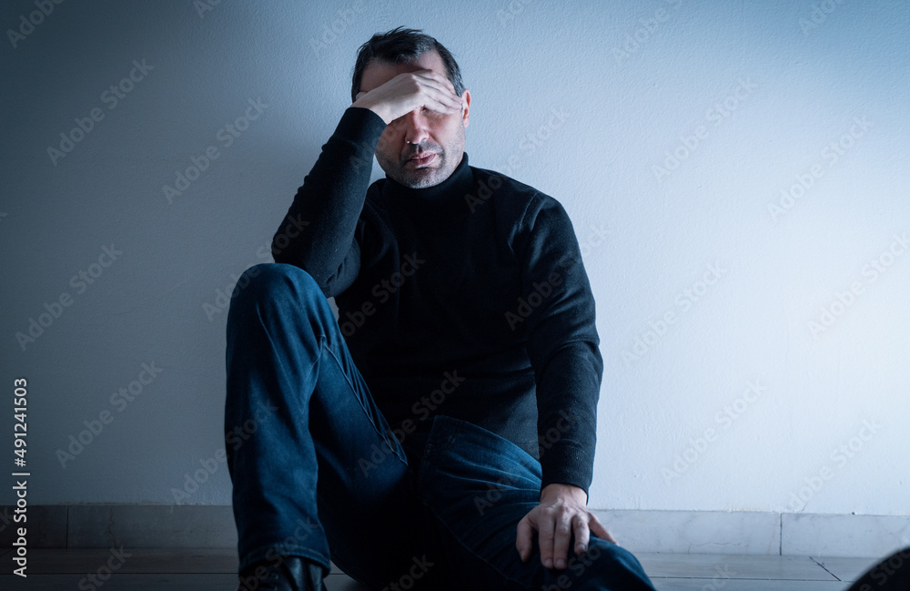 Sad man emotional portrait sitting and suffering depression feeling ...