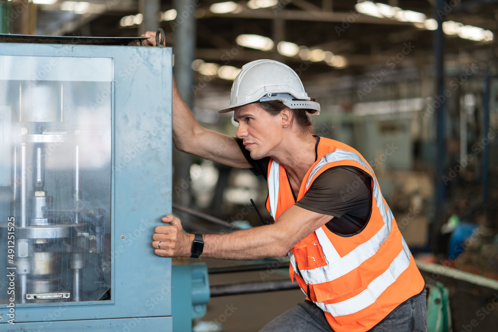 Male engineer in safety vest with helmet using laptop checking and ...
