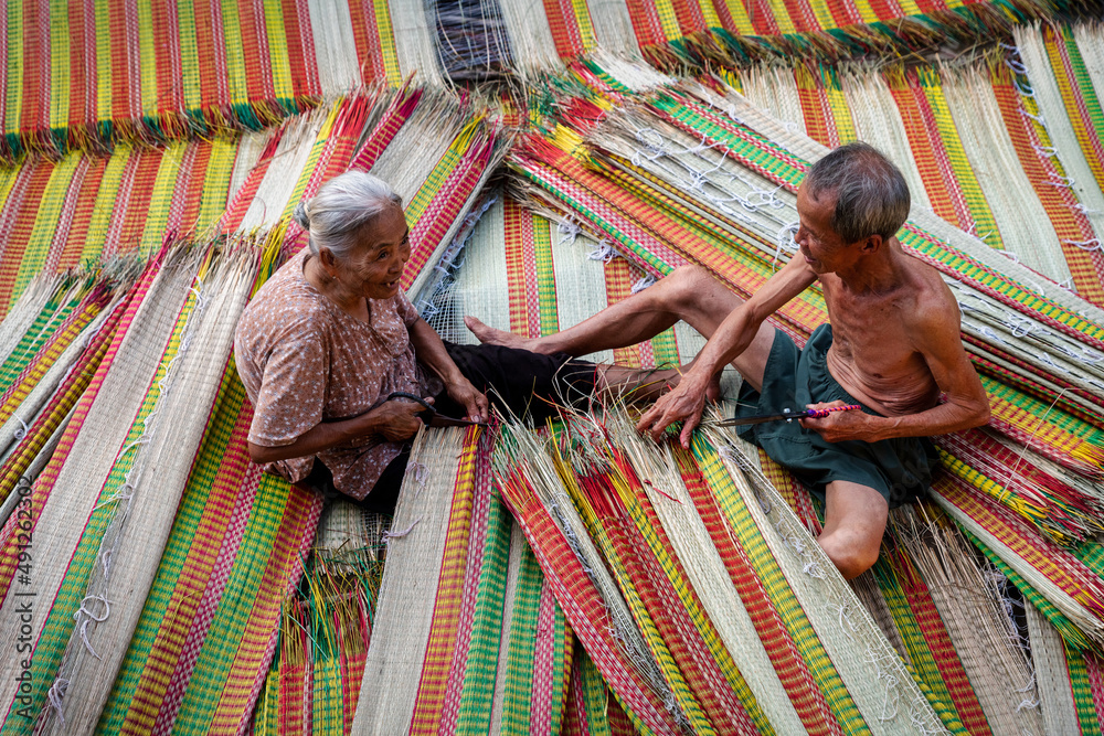 Vietnamese Old Man and Women Making a drying traditional vietnam mats ...