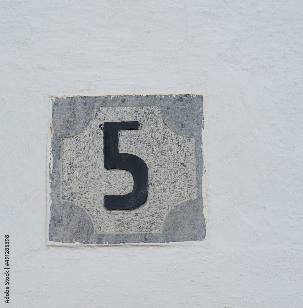 PLACA DEL NUMERO 5 EN UNA PARED BLANCA Stock Photo | Adobe Stock