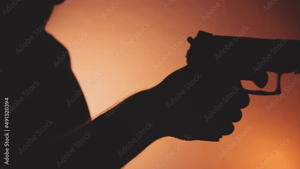 Silhouette of arm raising a pistol hand gun Stock Video | Adobe Stock