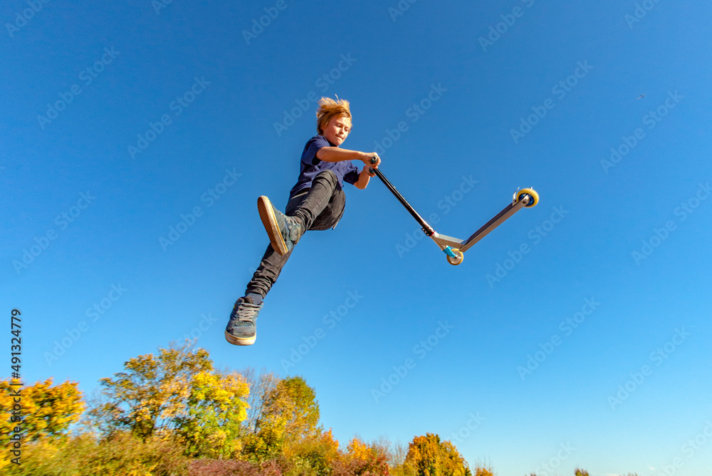 child going airborne with scooter Stock Photo | Adobe Stock