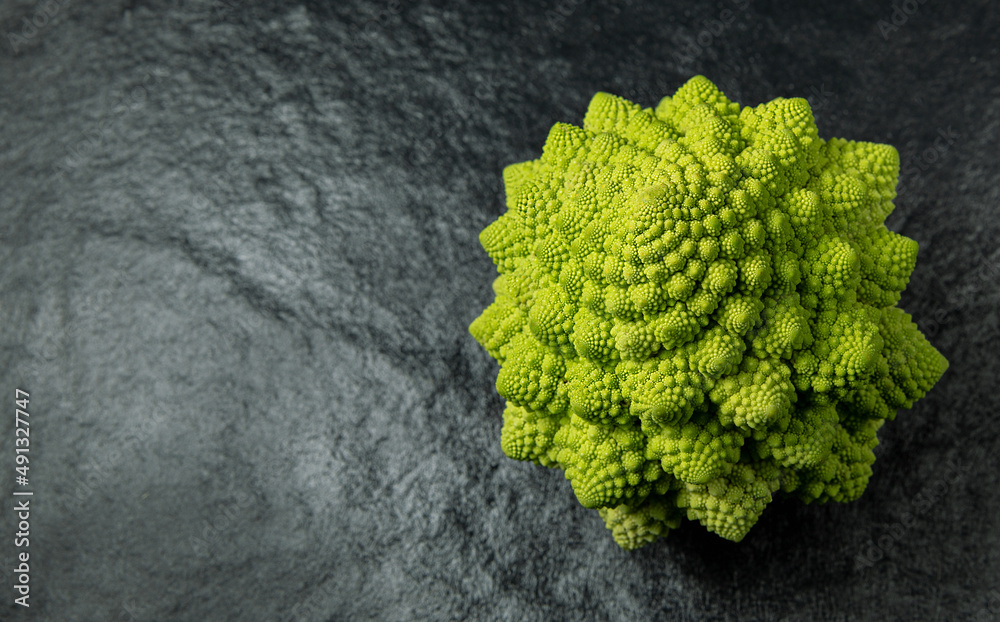 Romanesco broccoli head on a dark stone surface, cabbage, close up ...